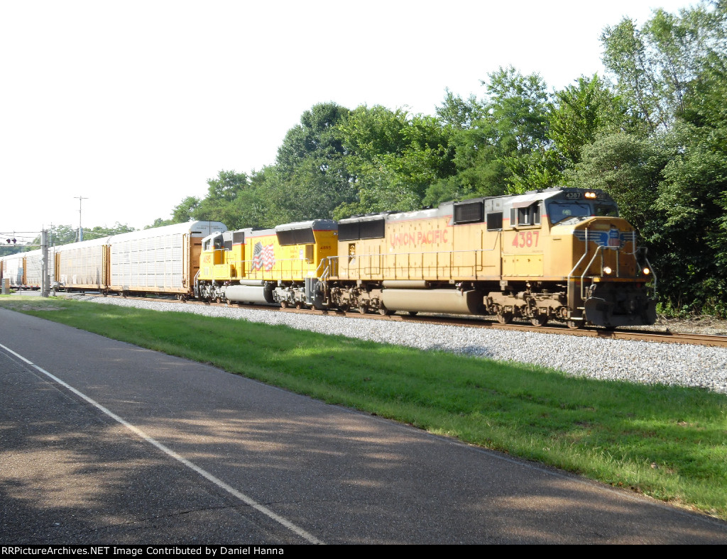 UP 4387 leads empty rack train 27W east